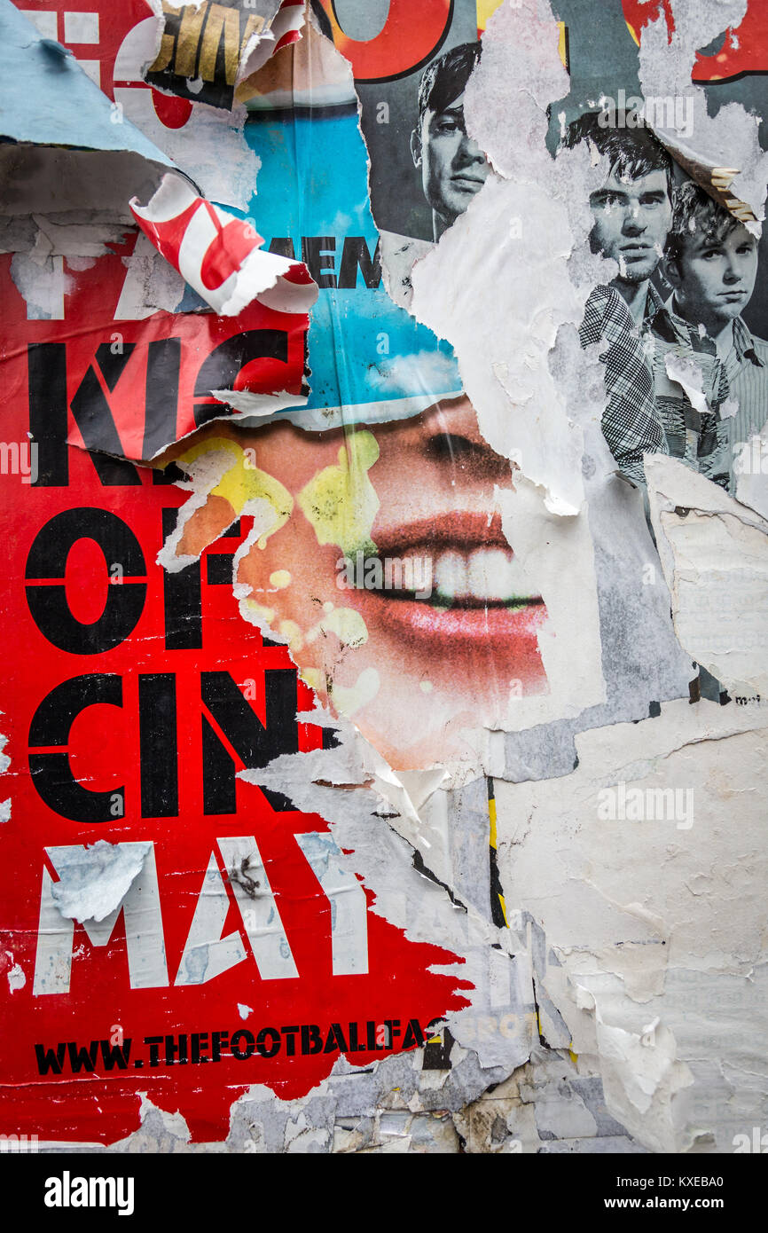 Ripped posters reveal the photograph of a smile Stock Photo - Alamy