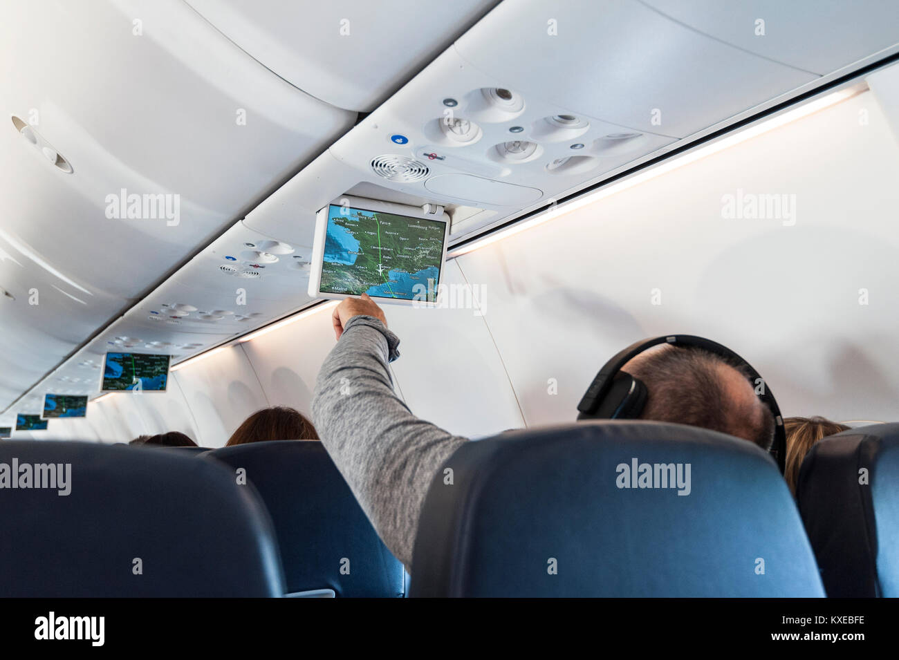 A passenger studying the map display on a Boeing 737 in flight on a TUI ...