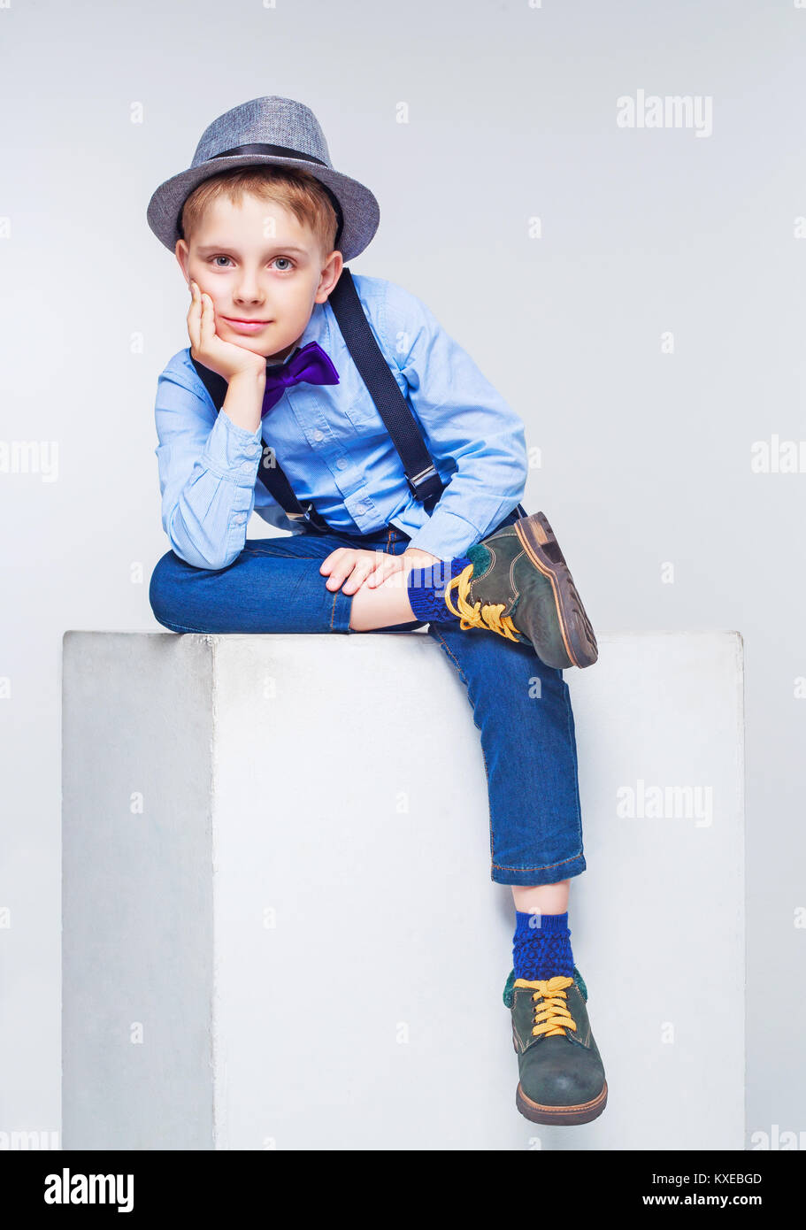 happy stylish boy wearing a hat and a tie, against white background ...