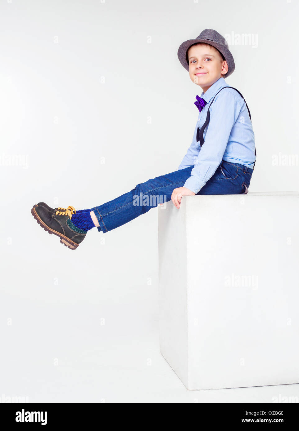 happy stylish boy wearing a hat and a tie, against white background ...