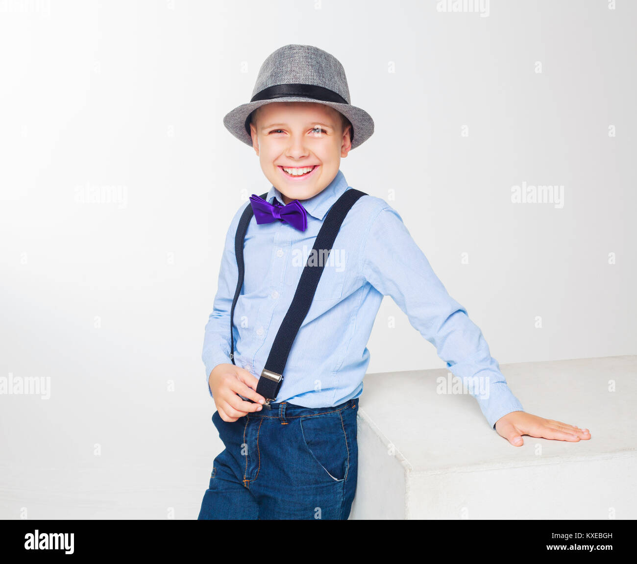 happy stylish boy wearing a hat and a tie, against white background ...