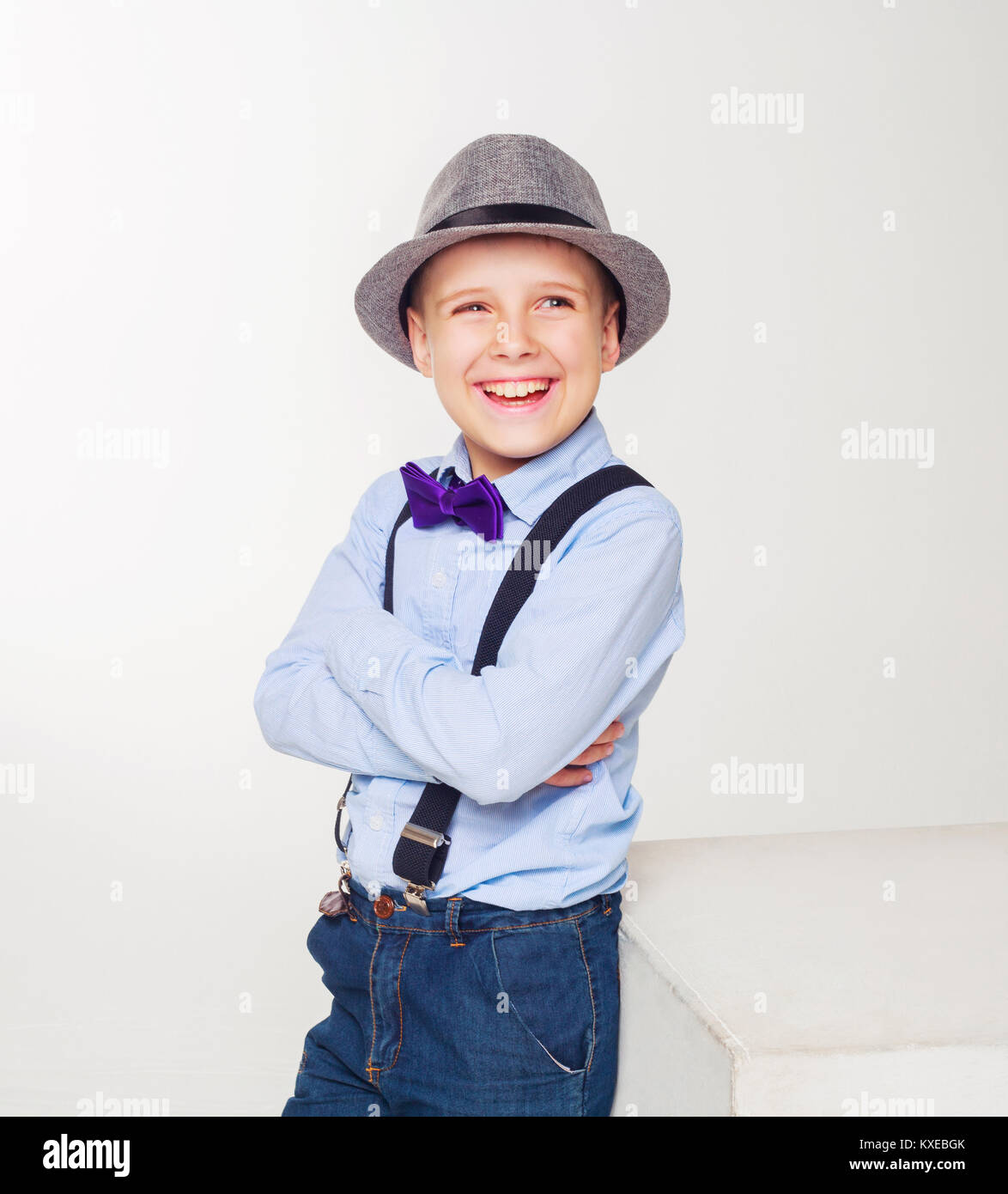 happy stylish boy wearing a hat and a tie, against white background ...