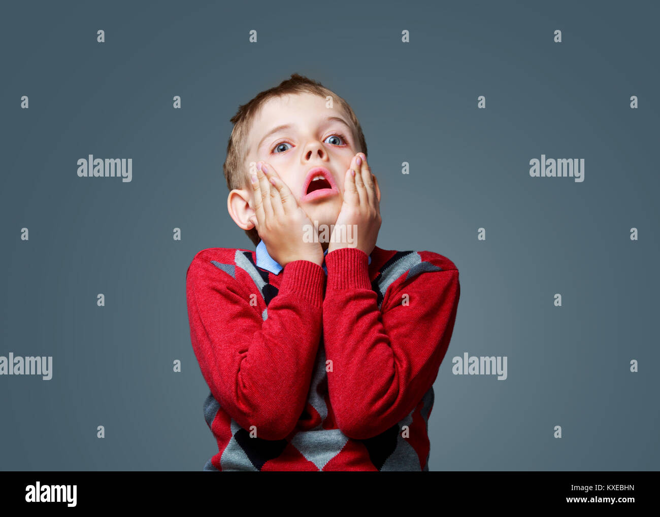 scared boy isolated against grey background Stock Photo - Alamy