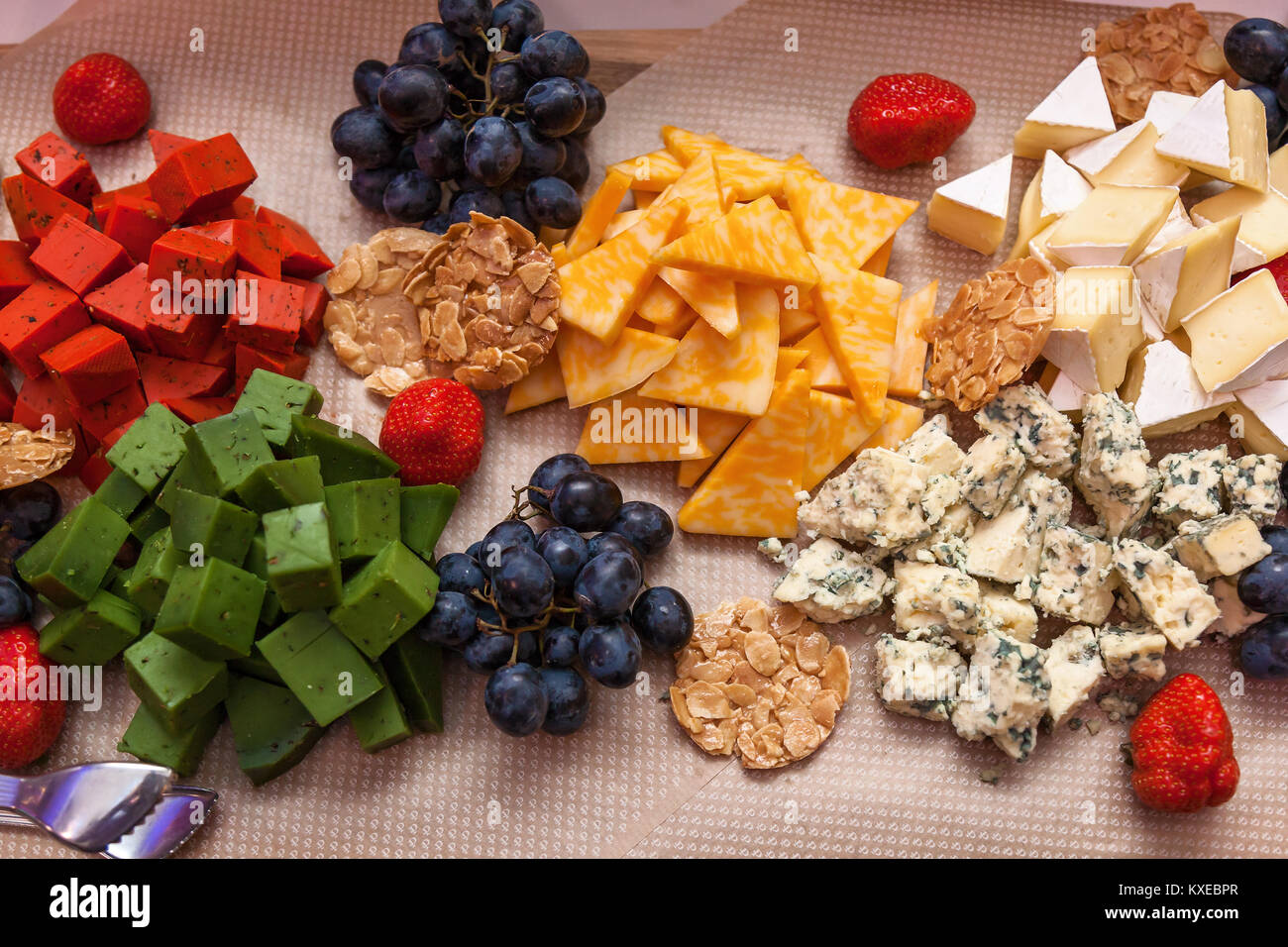 Cubes of red, green cheese with fruits on the table Stock Photo - Alamy