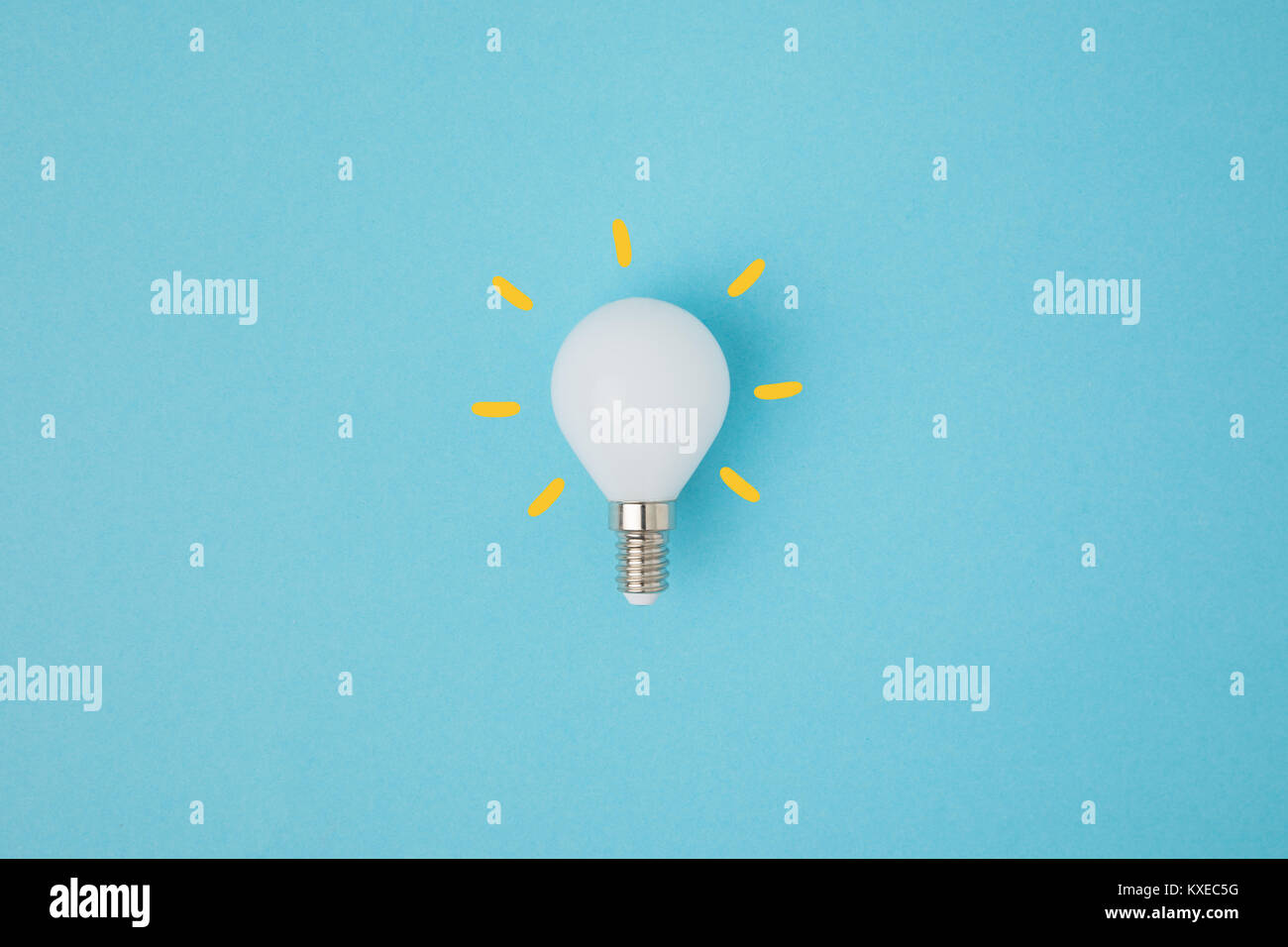 close up view of white light bulb with yellow lines isolated on blue ...