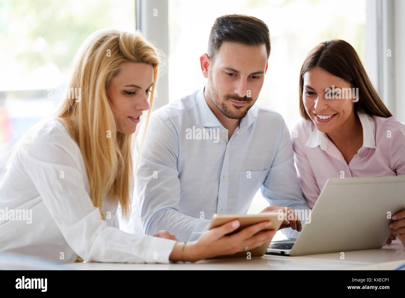 Workteam in office working together on laptop Stock Photo - Alamy