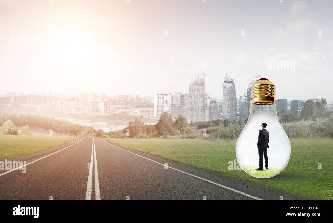 Businessman inside light bulb Stock Photo - Alamy