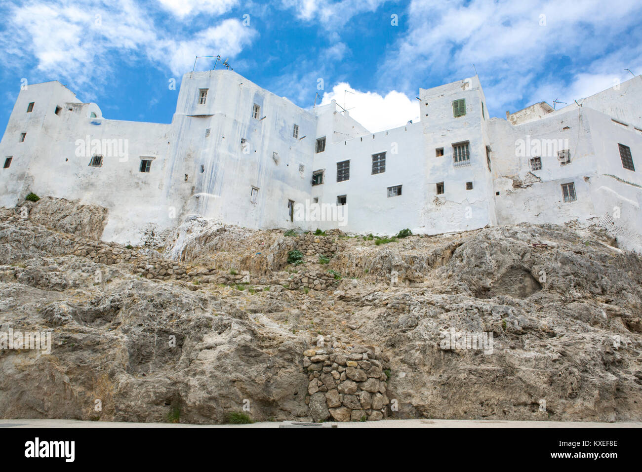 Houses built over coast rocks with traditional whitewashed exterior ...