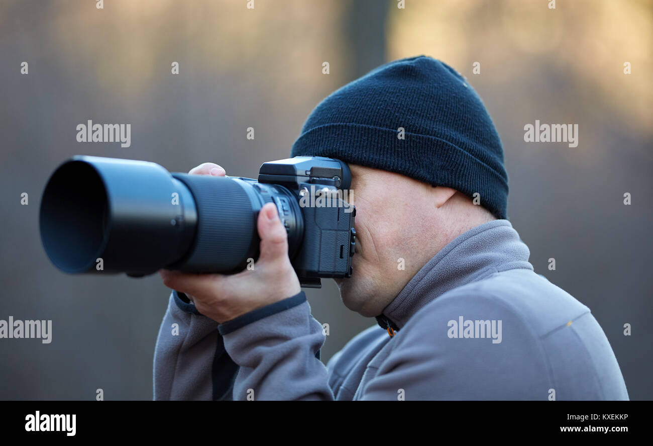 Photographer with professional camera taking pictures outdoor Stock ...