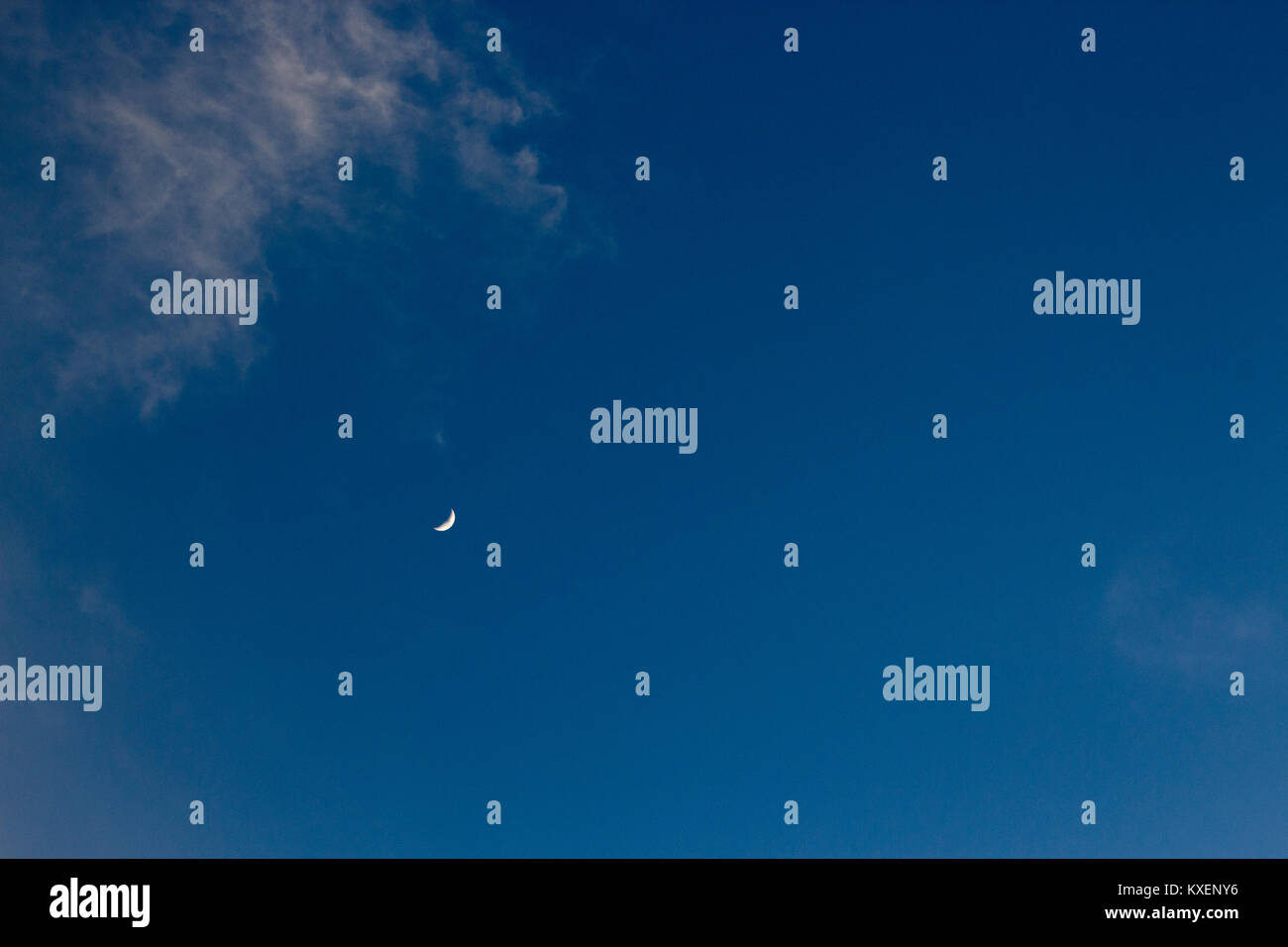 View of small crescent moon in the blue sky and cloud with copy space ...