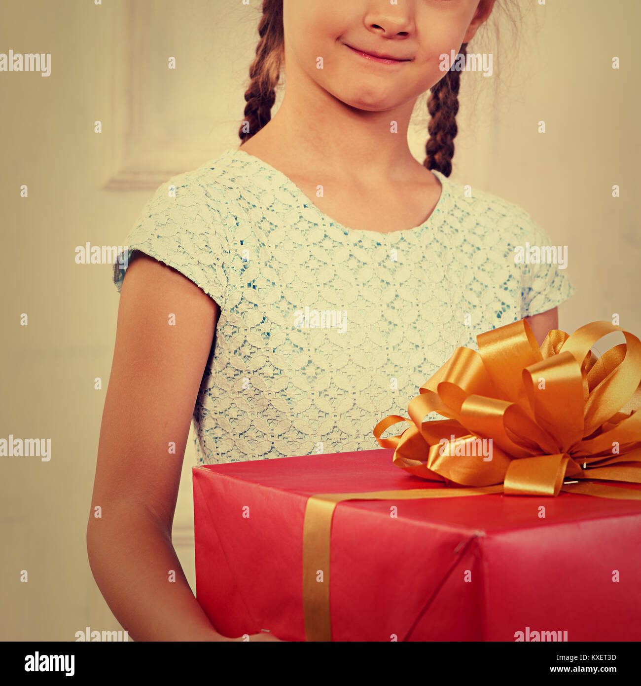 Beautiful cute kid girl holding big present box with red ribbon bow and ...