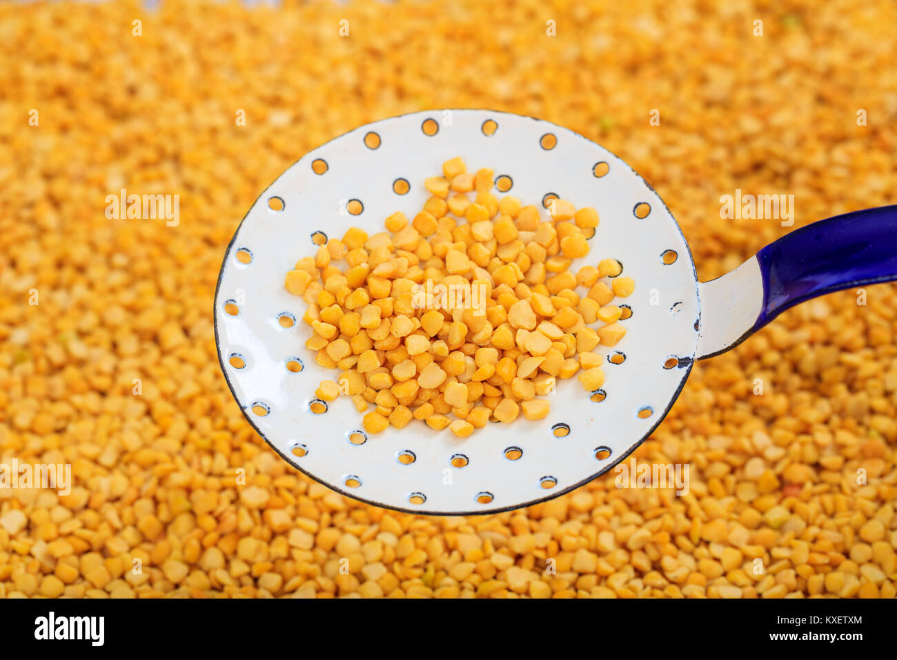 Metallic spoon on raw split peas background Stock Photo - Alamy
