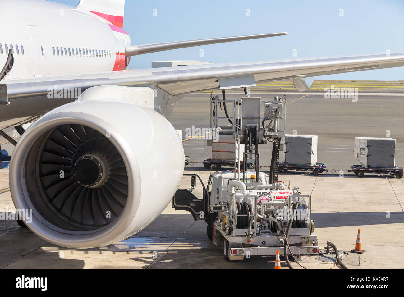 Truck parked under an aircraft wing refuelling the tanks with aviation ...