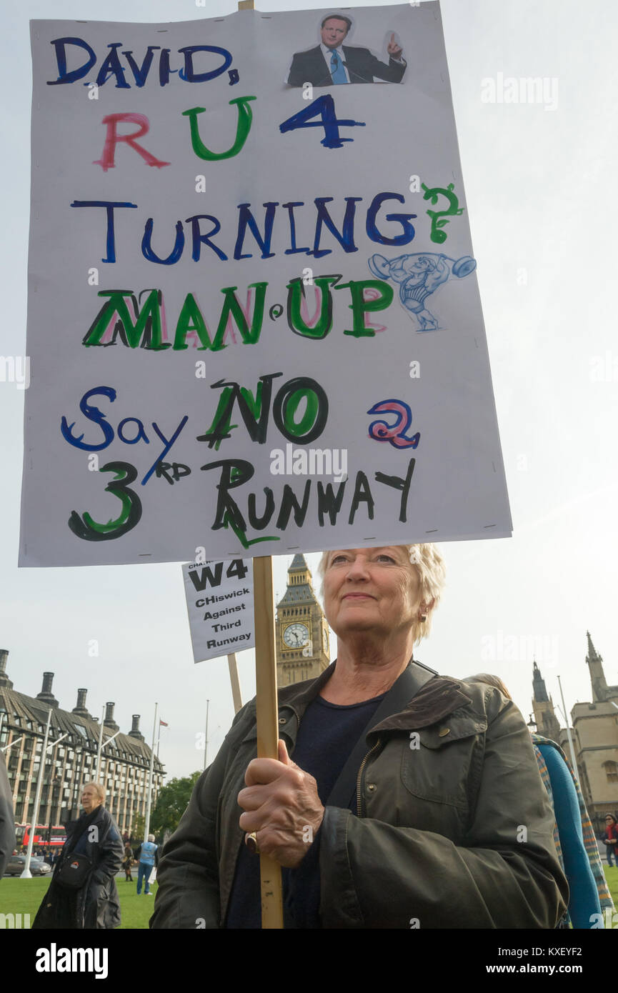 A woman holds a large poster reminding David Cameron of his total ...