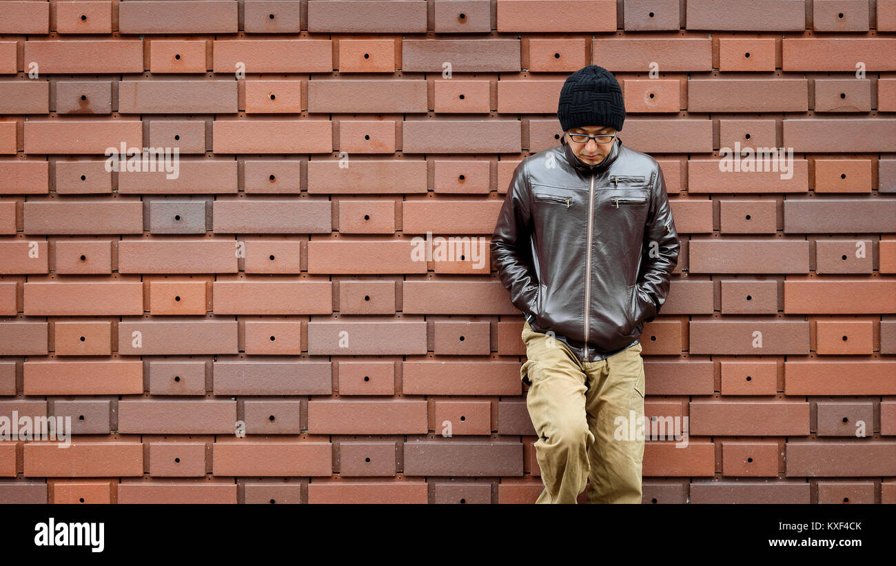 Man lean against brick wall hi-res stock photography and images - Alamy