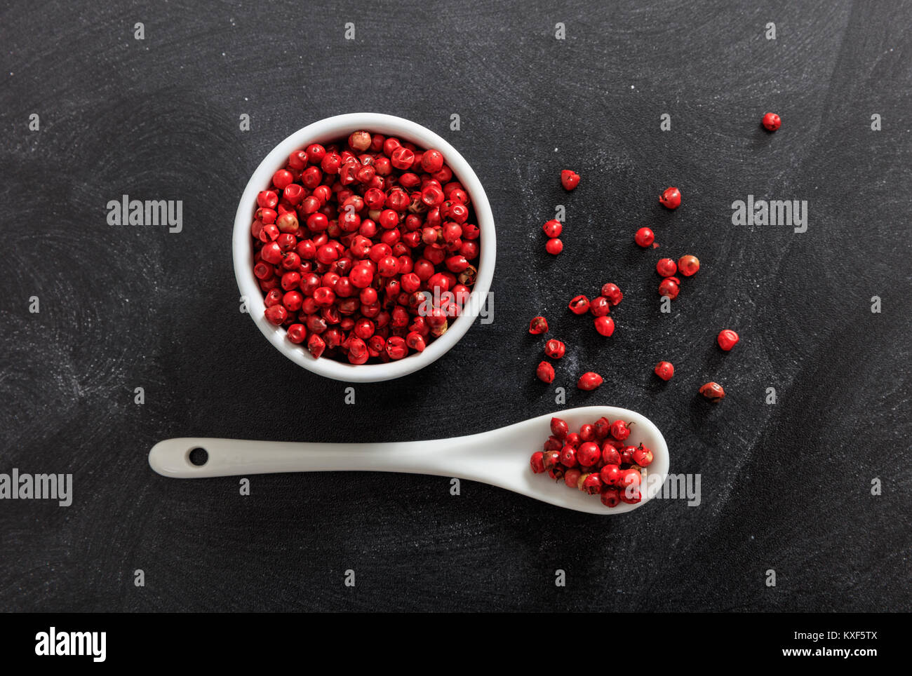 Red pepper spice seeds in porcelain bowl and spoon, black background ...