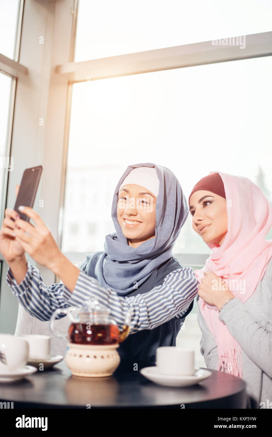 young beautiful muslim woman taking a self portrait with camera phone ...
