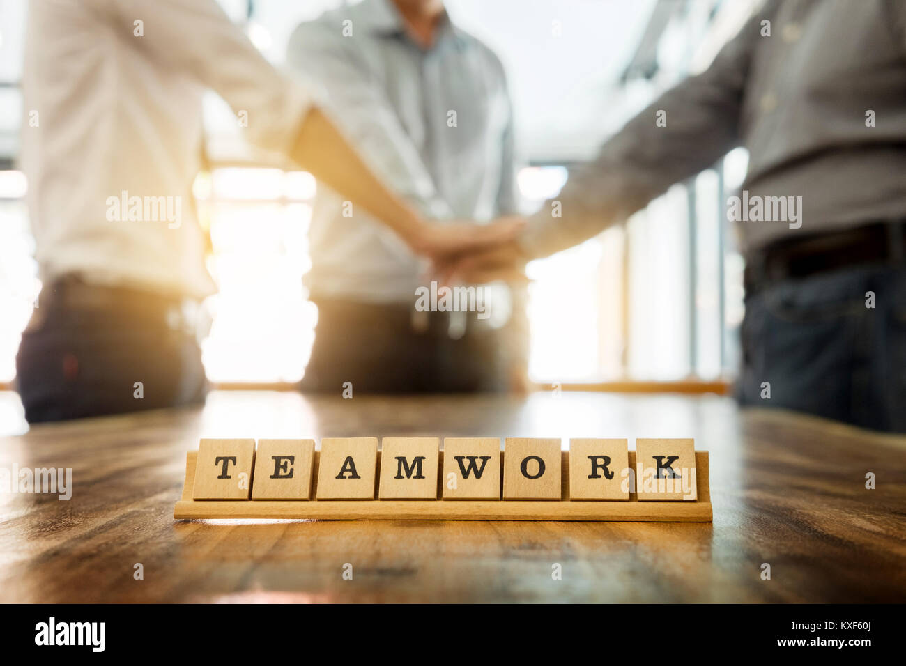 Teamwork word on wood table with Business team work join hands together ...