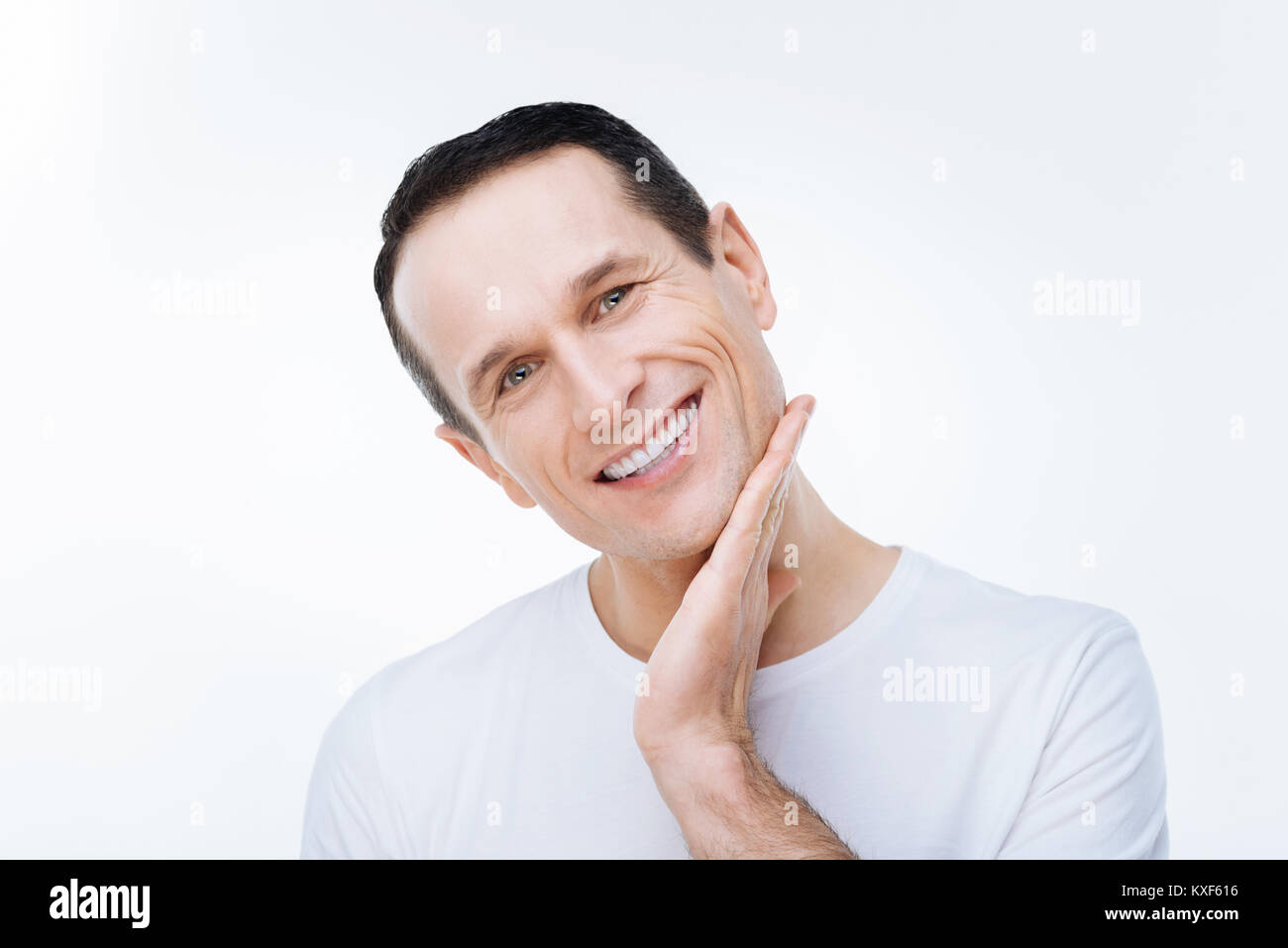 Happy cheerful man touching his chin Stock Photo - Alamy