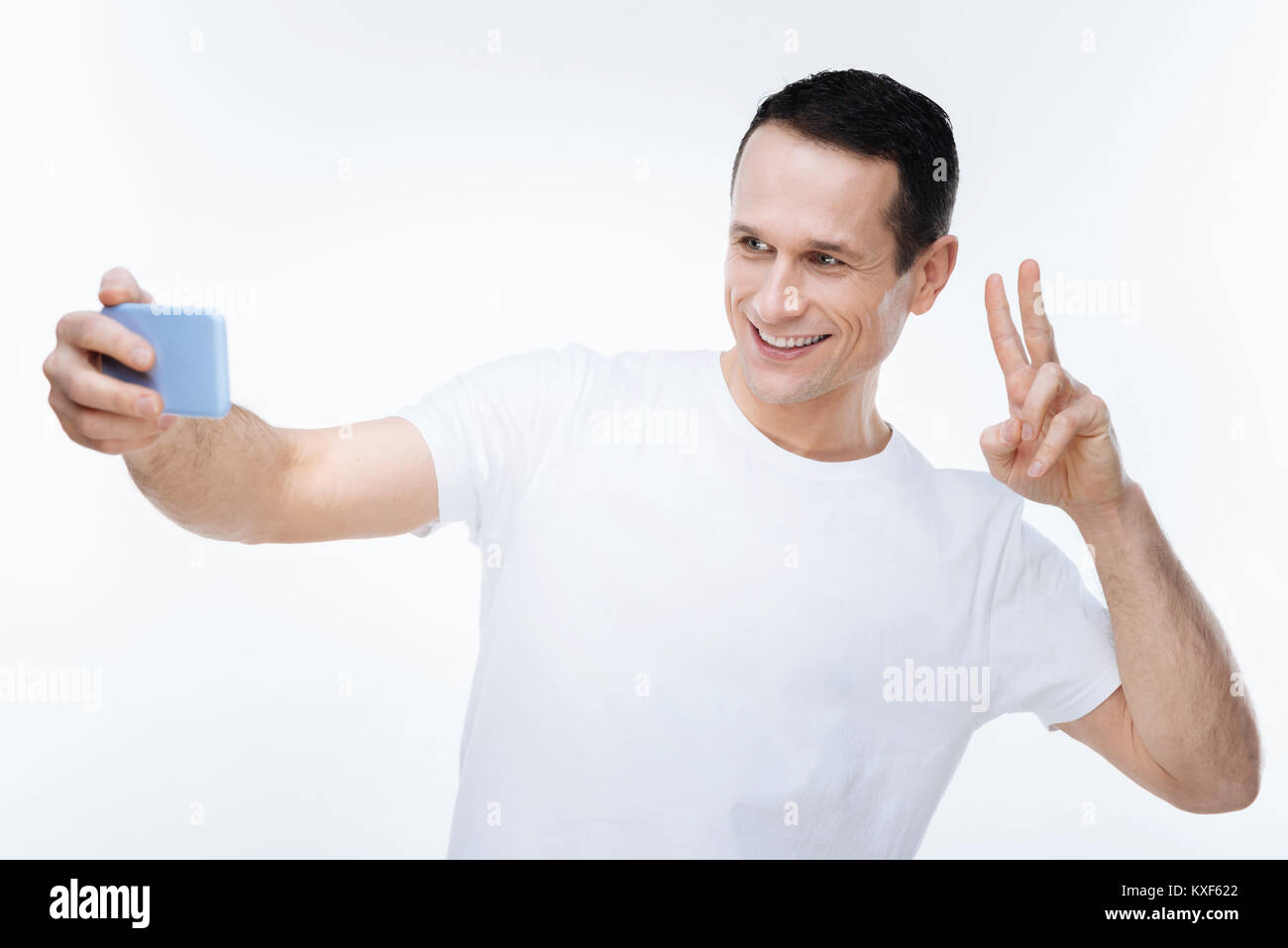 Nice positive man showing V sign Stock Photo - Alamy