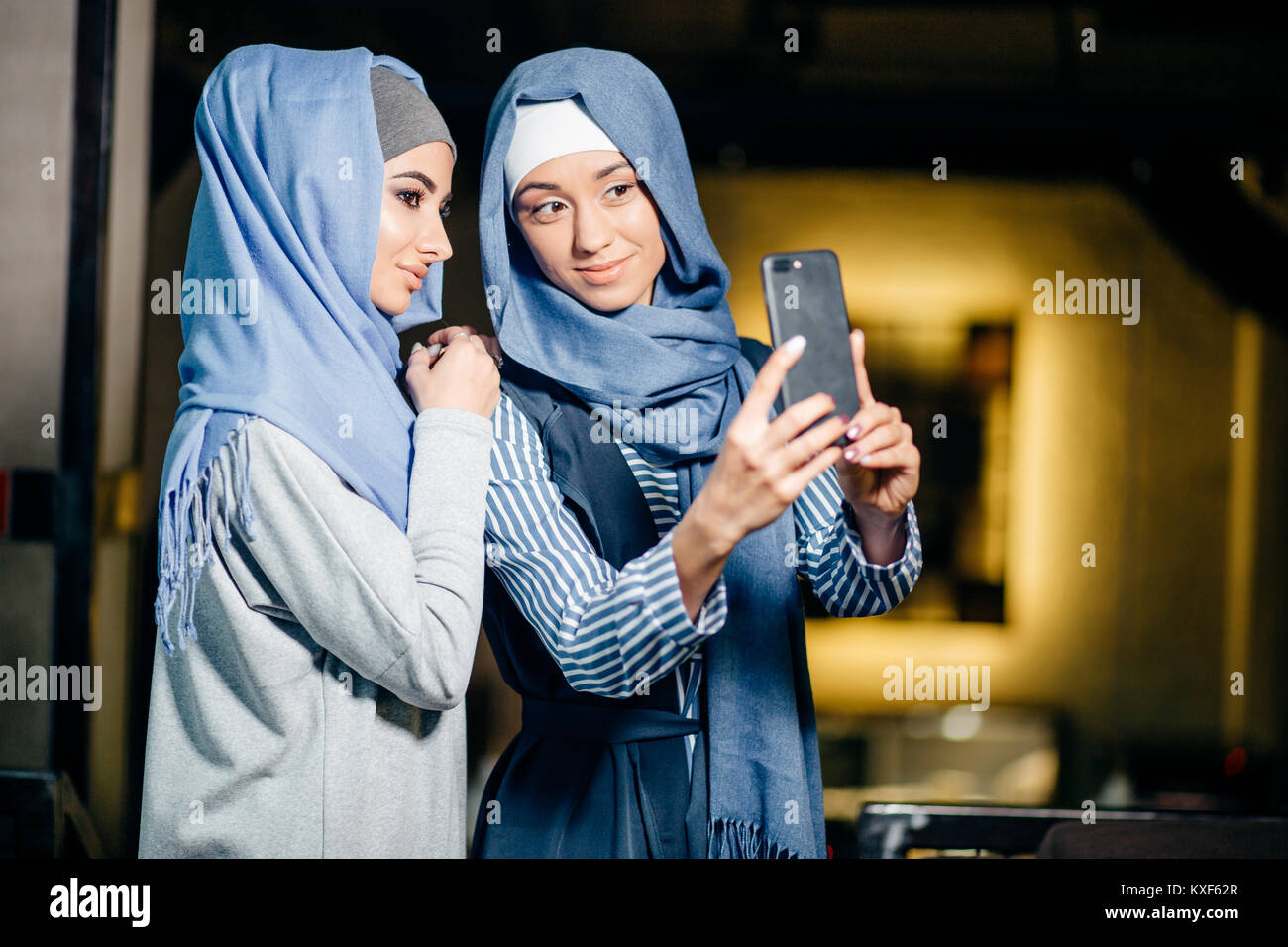 young beautiful muslim woman taking a self portrait with camera phone ...