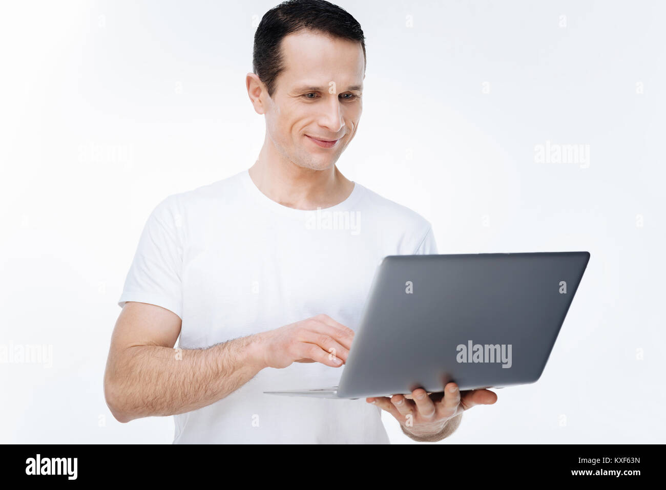 Cheerful happy man holding a laptop Stock Photo - Alamy