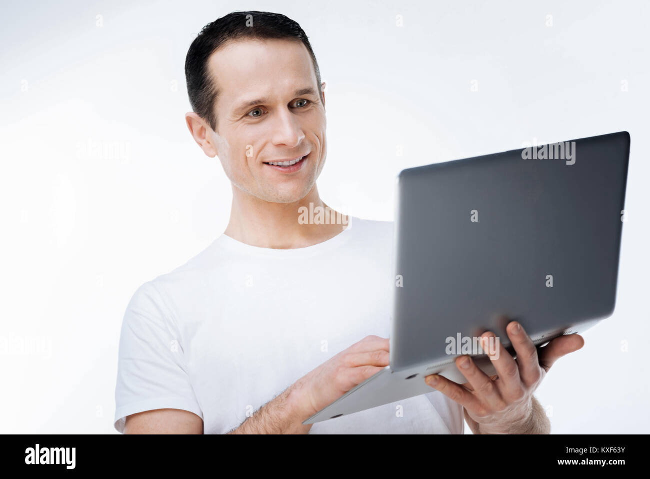 Positive smart man looking at the laptop screen Stock Photo - Alamy