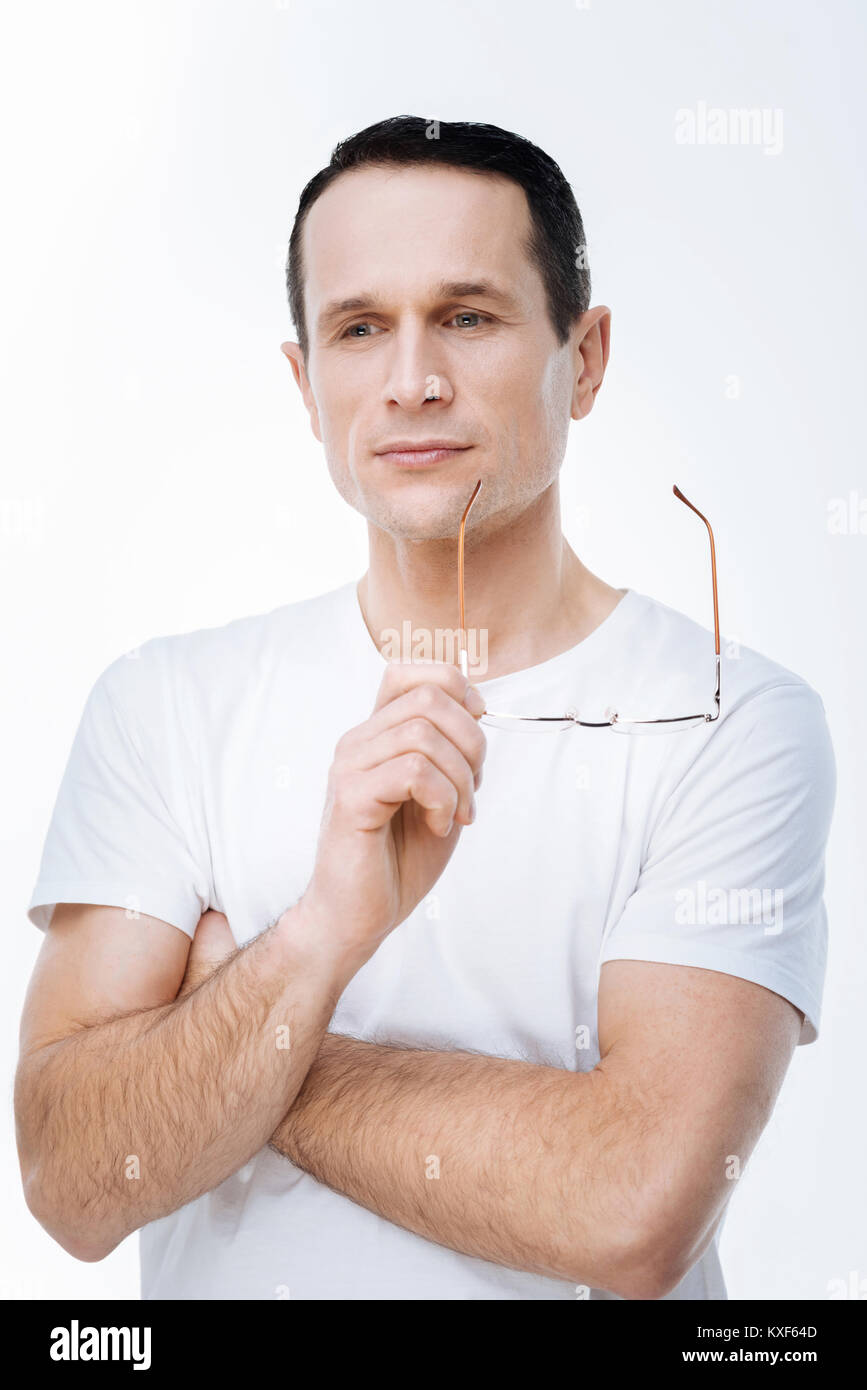 Handsome thoughtful man holding his glasses Stock Photo - Alamy
