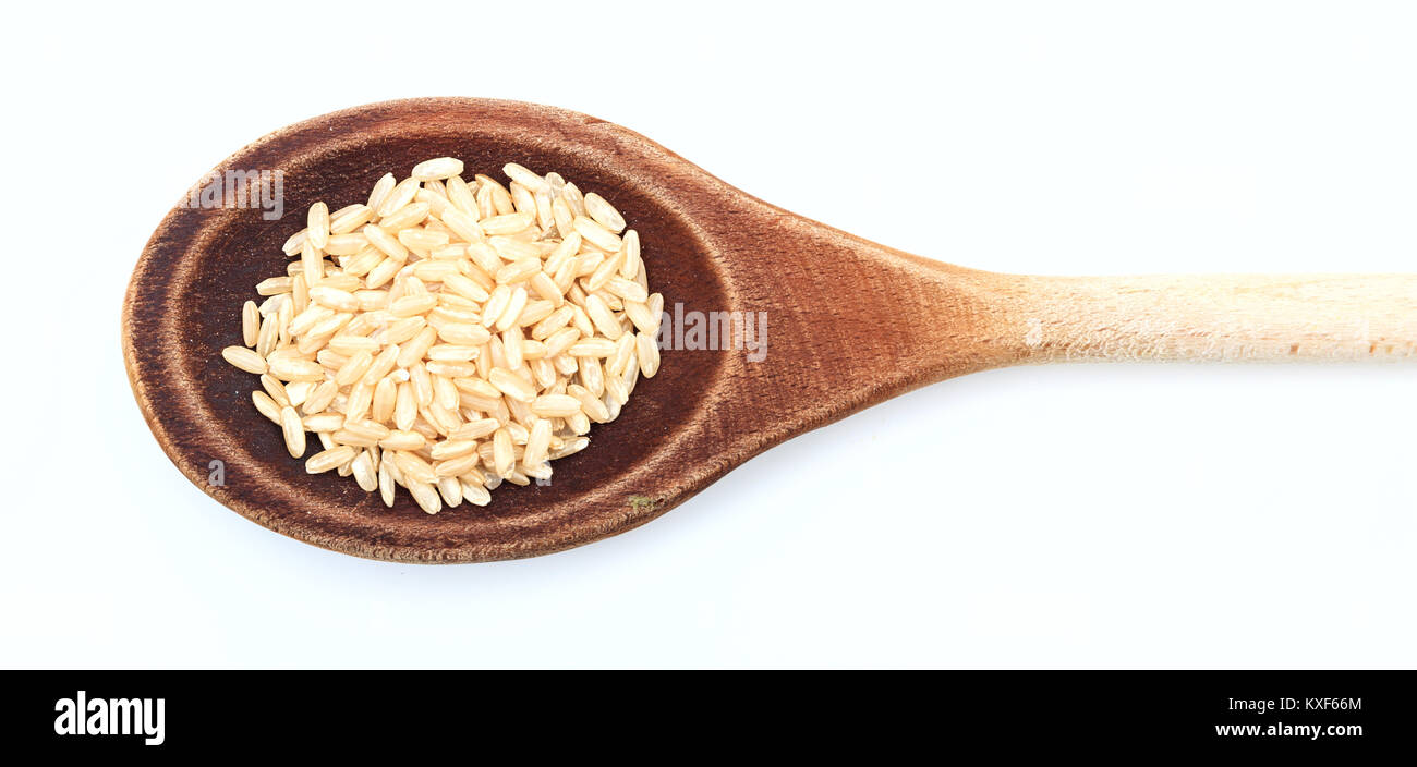 Raw unrefined rice in a wooden spoon on white background Stock Photo ...