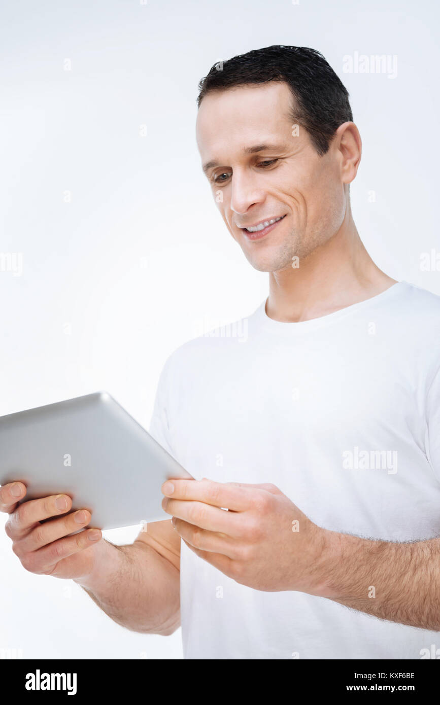 Happy cheerful man looking at the tablet screen Stock Photo - Alamy