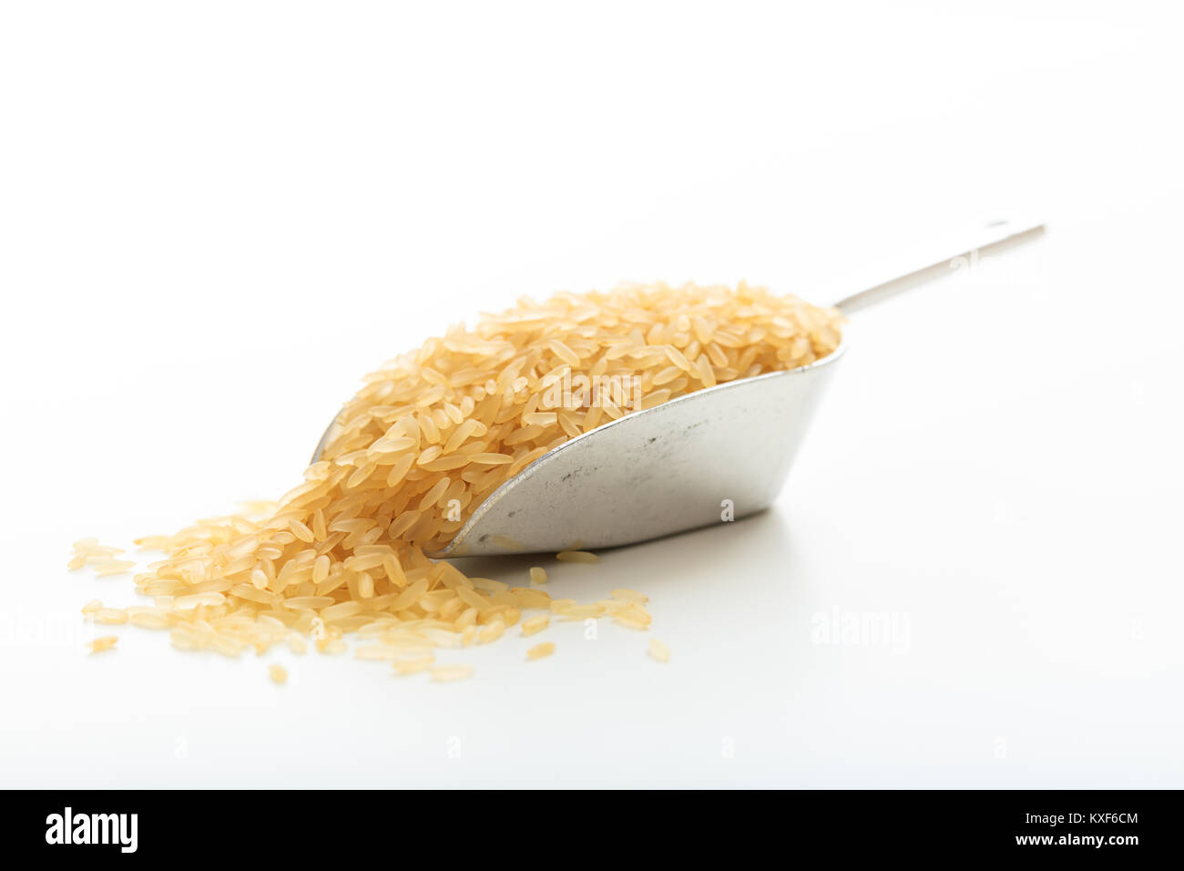 Raw parboiled rice in a metallic scoop on white background Stock Photo ...
