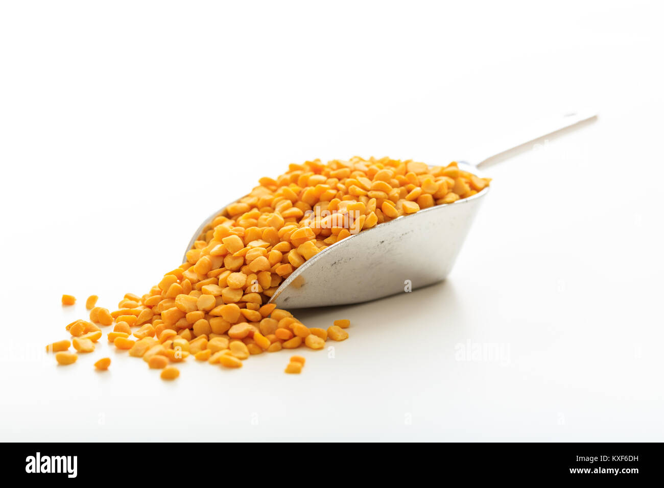 Raw split peas in a metallic scoop on white background Stock Photo - Alamy