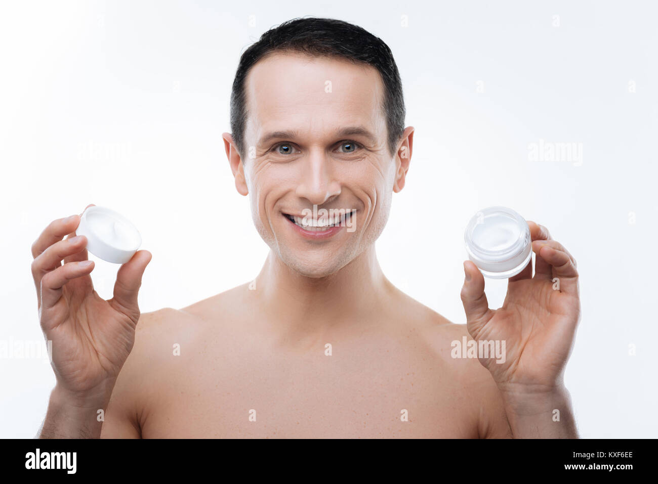 Portrait of a positive cheerful man using cosmetics Stock Photo - Alamy