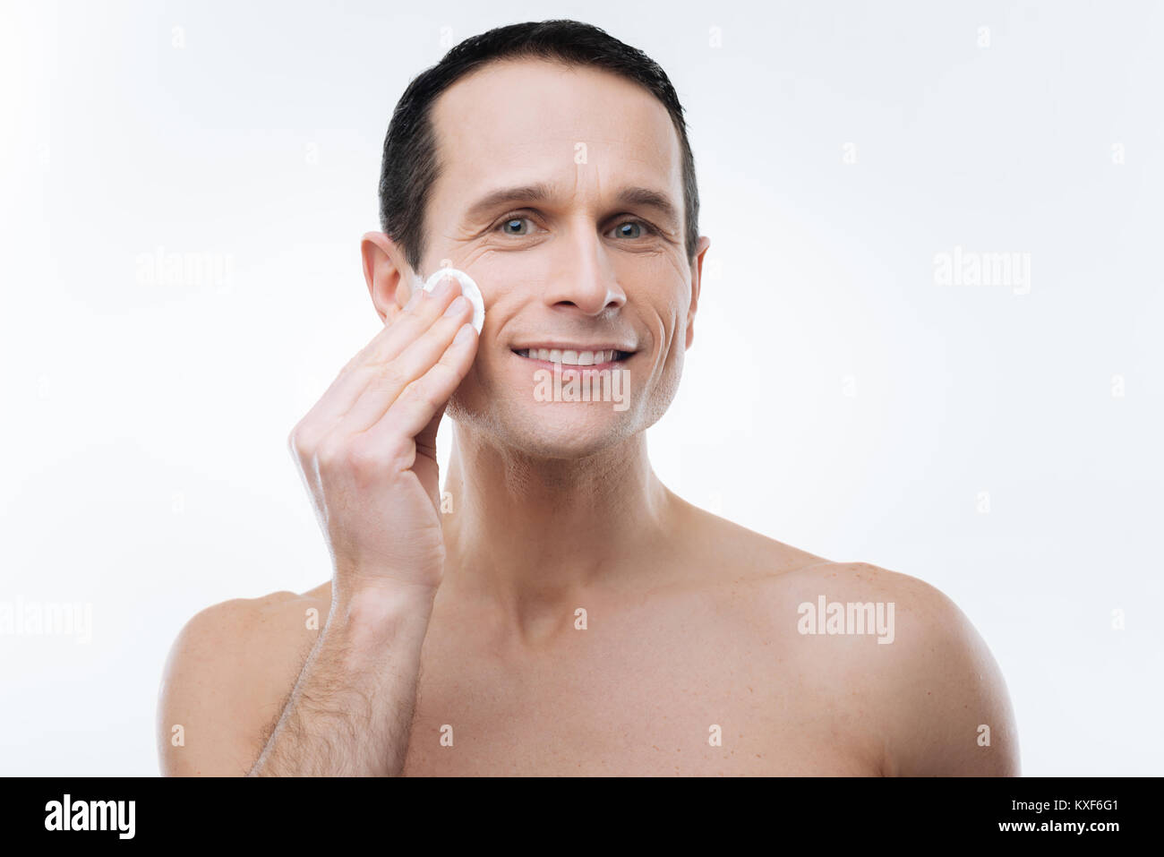 Cheerful joyful man caring about his skin Stock Photo - Alamy