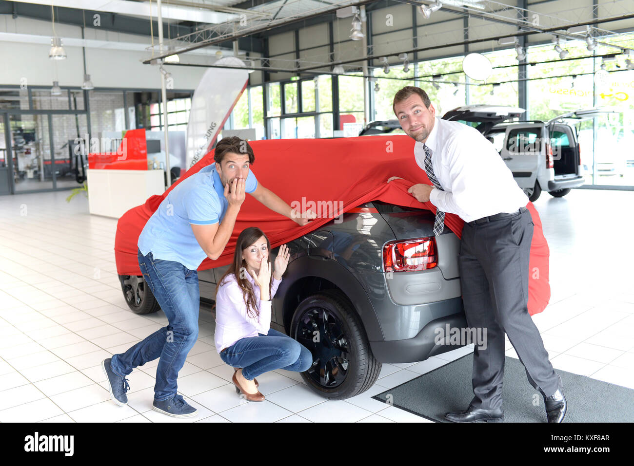 couple in the car dealership in front of a new vehicle, secret car ...