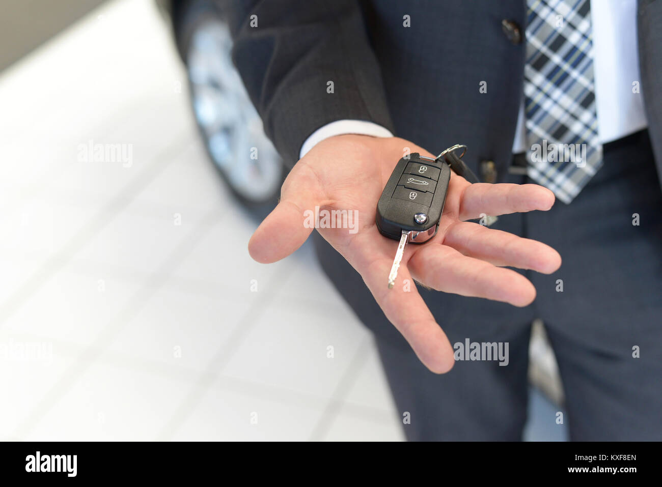 customer in the car dealership holds the car key of the newly purchased ...