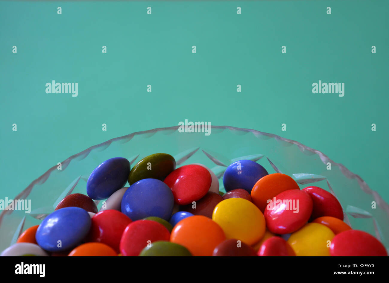 Multi coloured candies in a crystal bowl on a plain background Stock ...