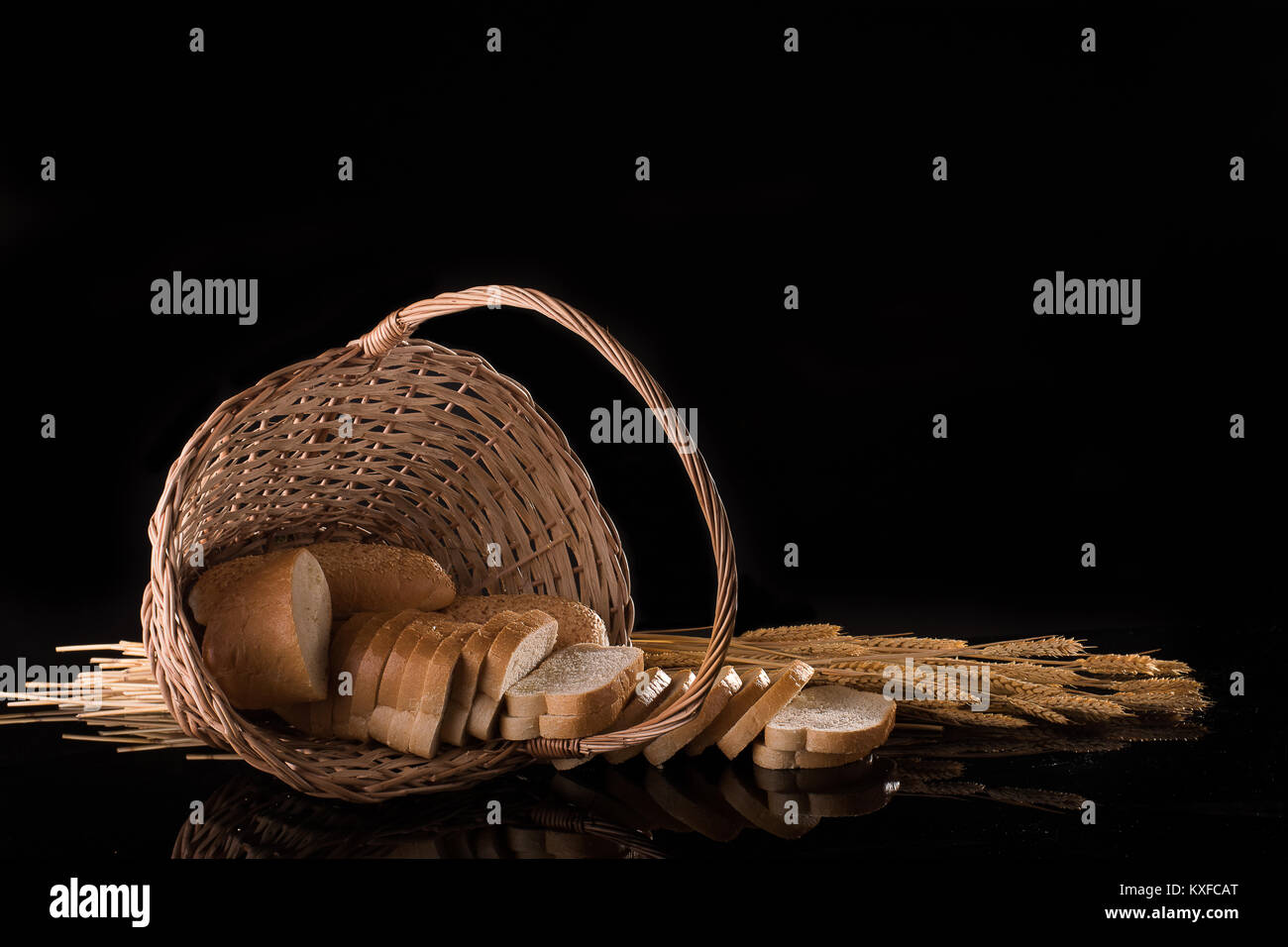 Basket full of bread and wheat on black background Stock Photo - Alamy