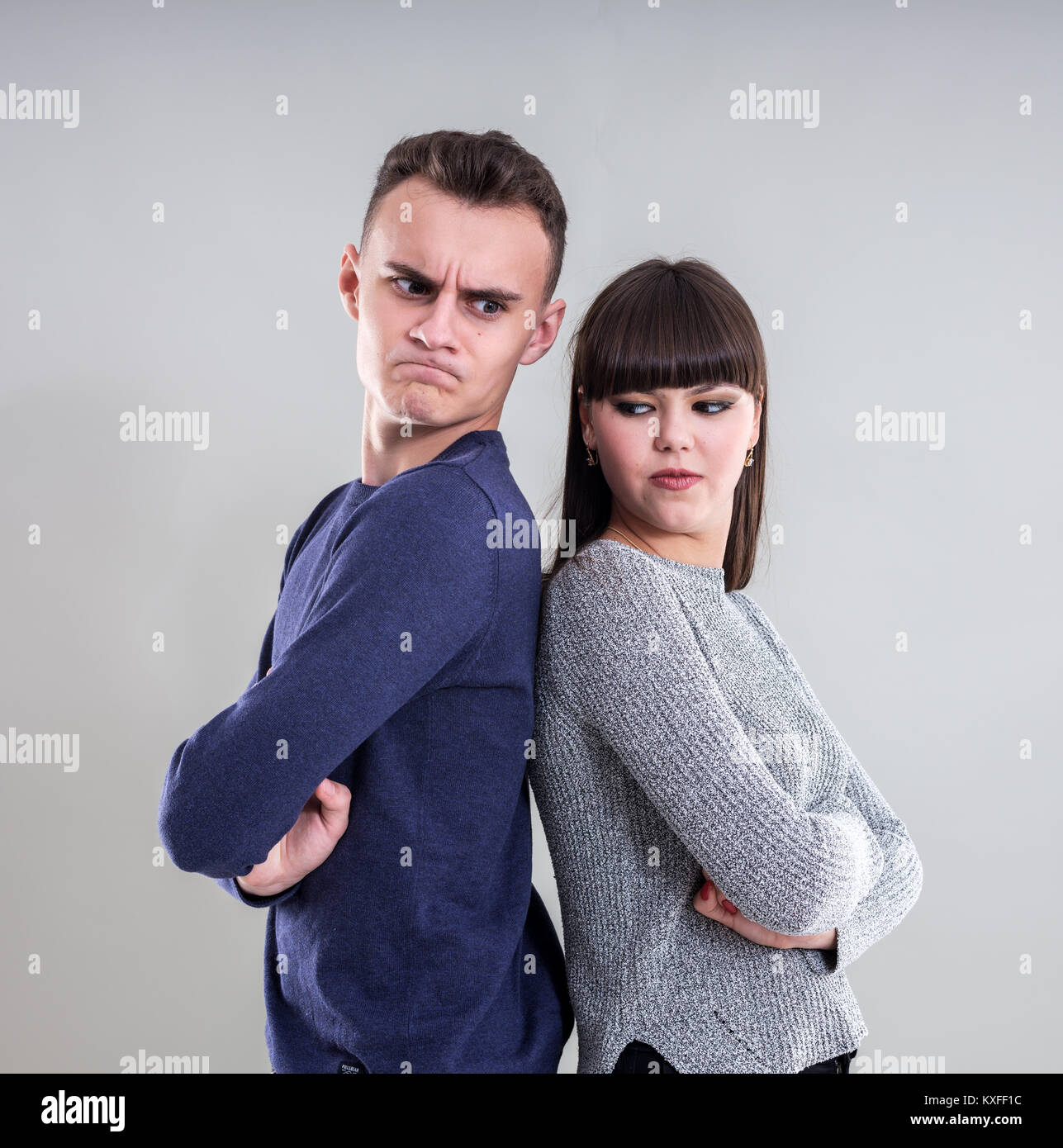 Two upset teenagers standing back to back Stock Photo - Alamy