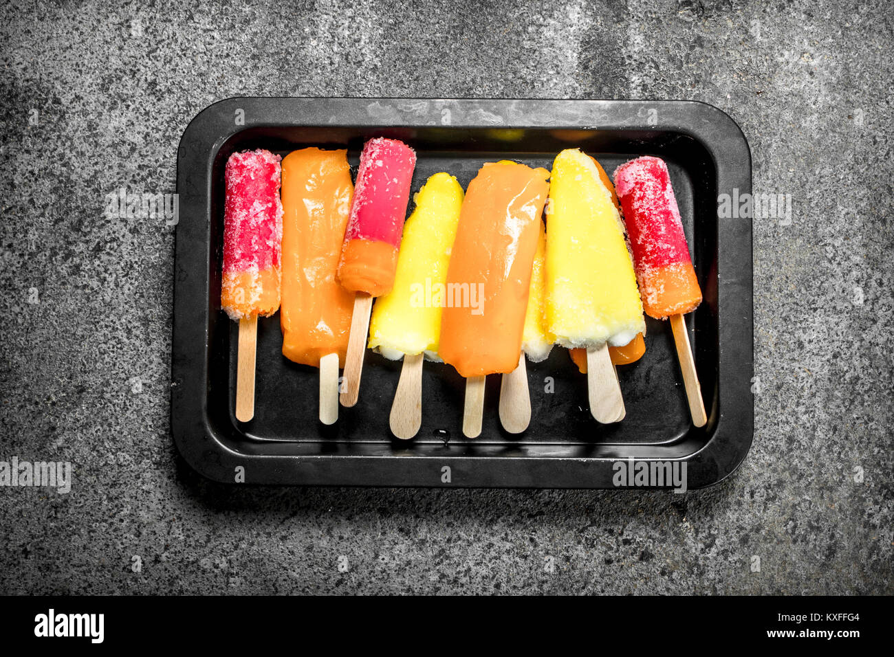 Multicolored fruit ice made from fruits. On a rustic background Stock ...