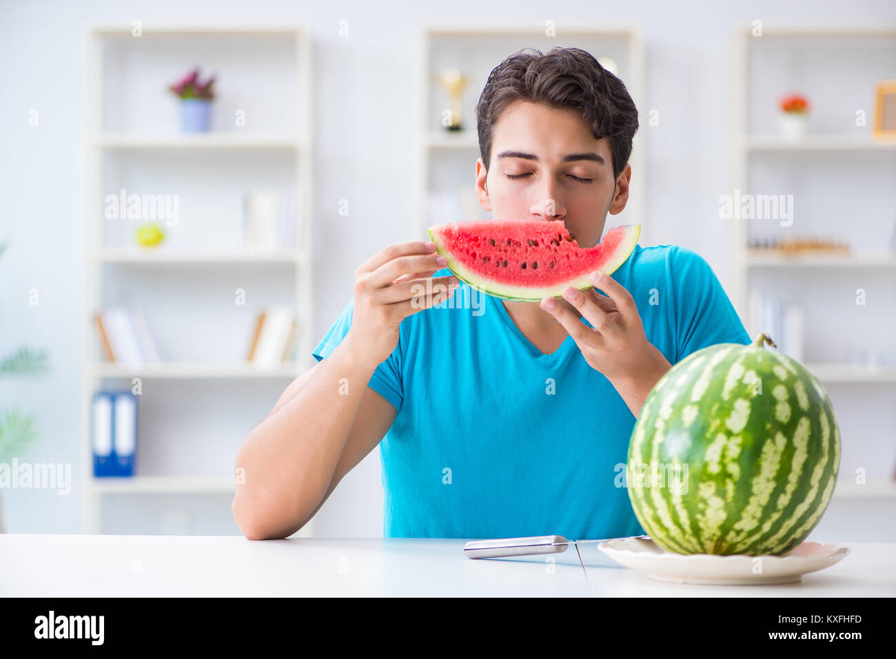 Man eating watermelon at home Stock Photo - Alamy
