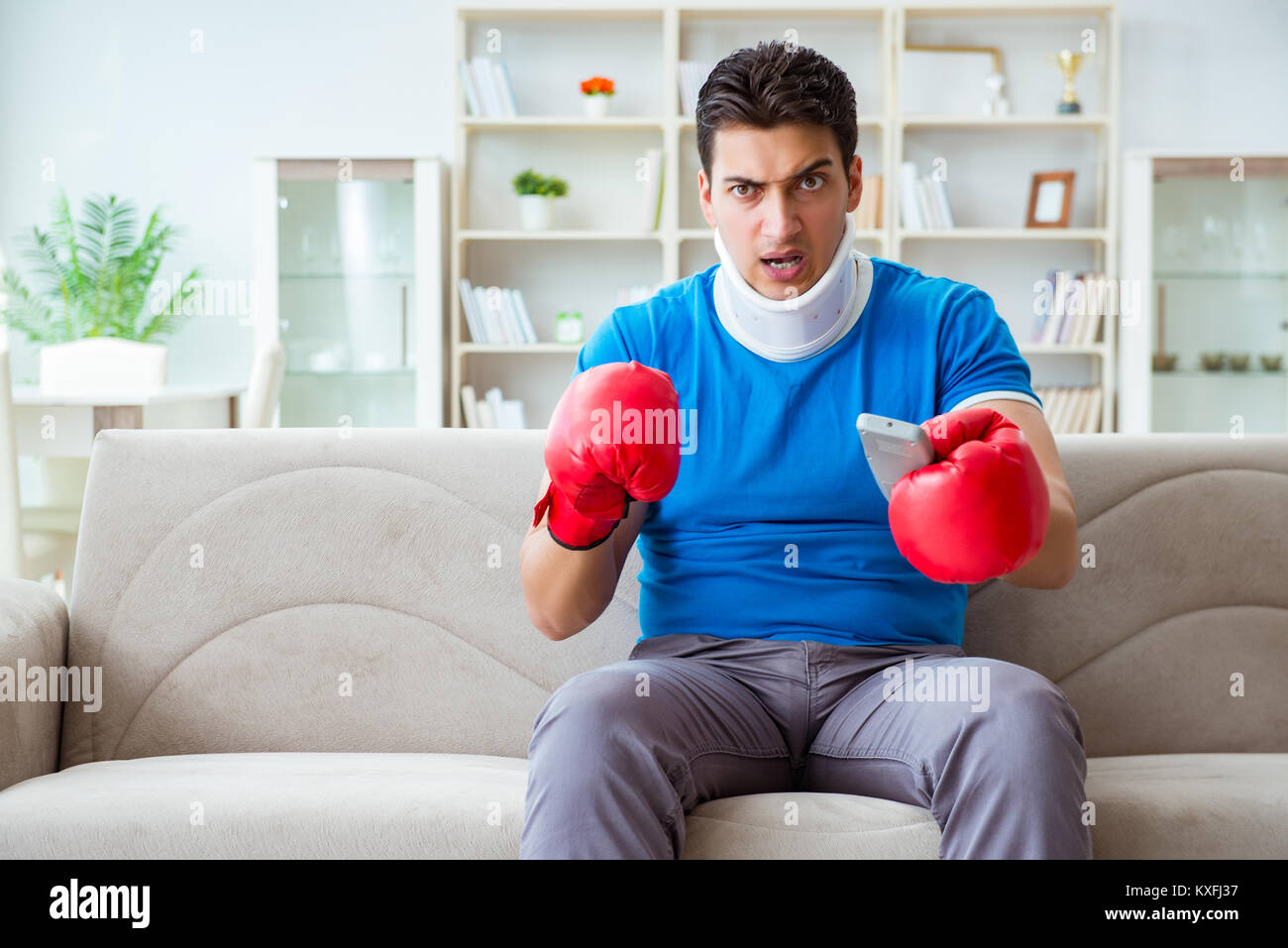 Man with neck injury watching boxing at home Stock Photo - Alamy