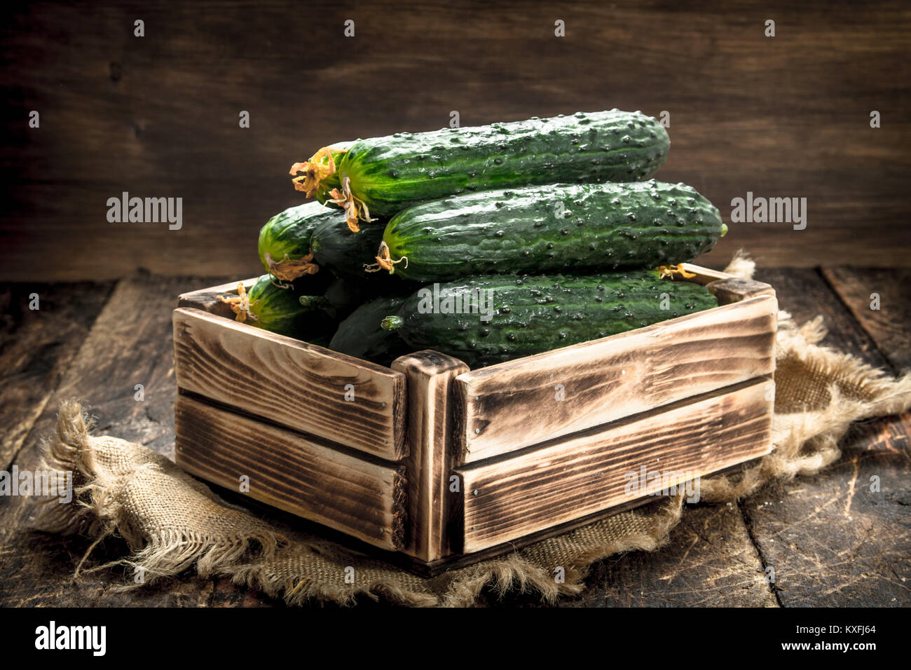 Fresh cucumbers in an old box. On a wooden background Stock Photo - Alamy