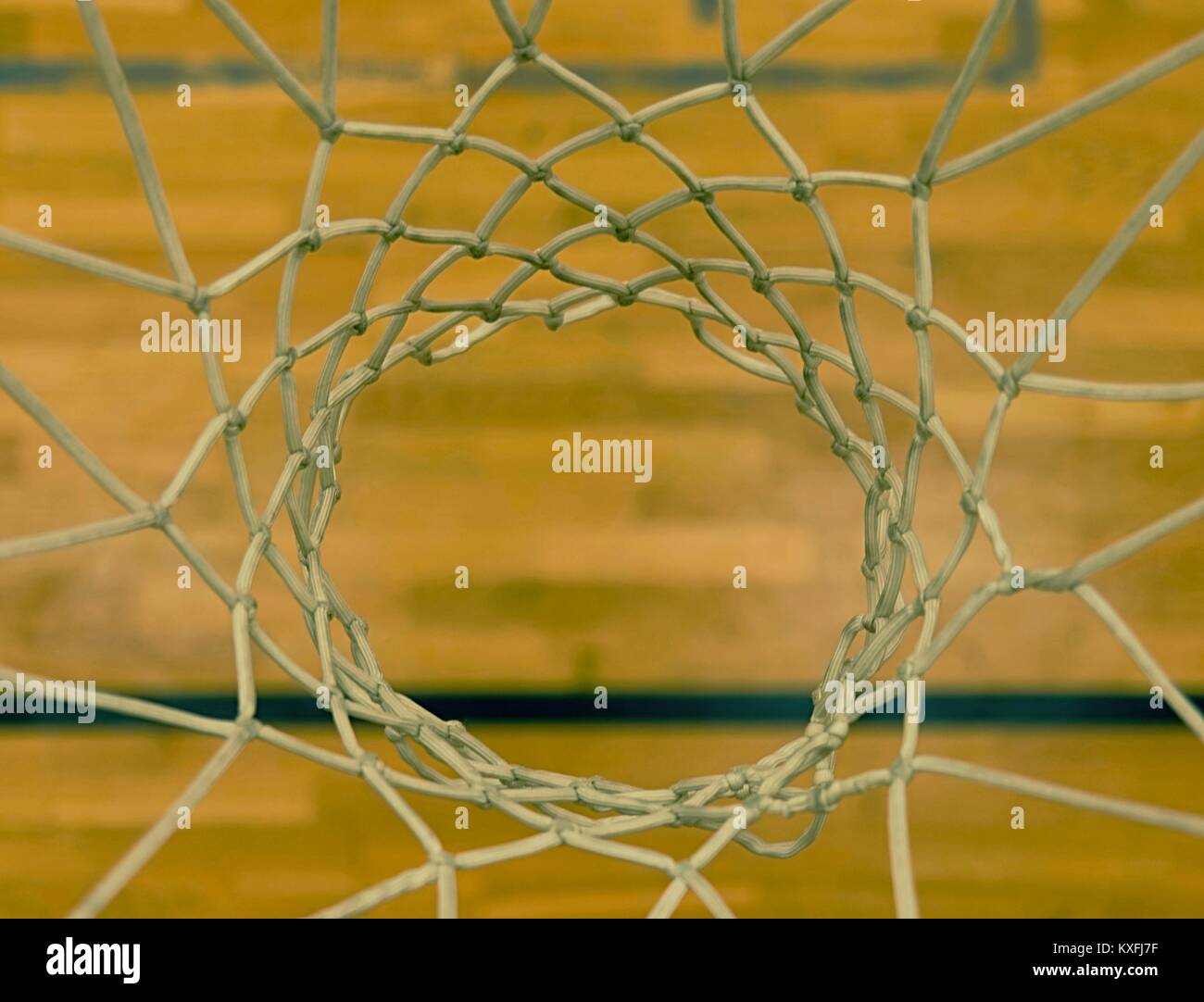 View through basketball hoop. Looking to floor through white net from ...