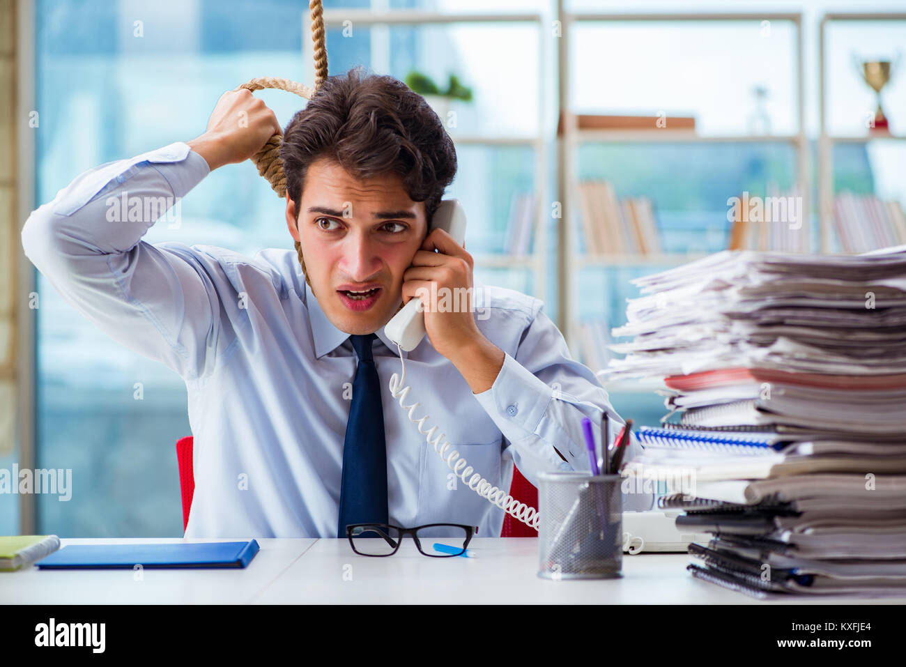 Unhappy businessman thinking of hanging himself in the office Stock ...