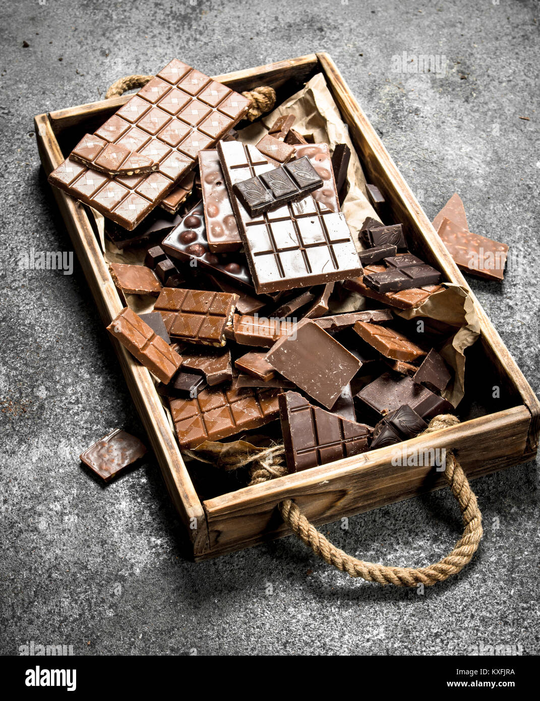Broken chocolate bars on wooden tray. On a rustic background Stock ...