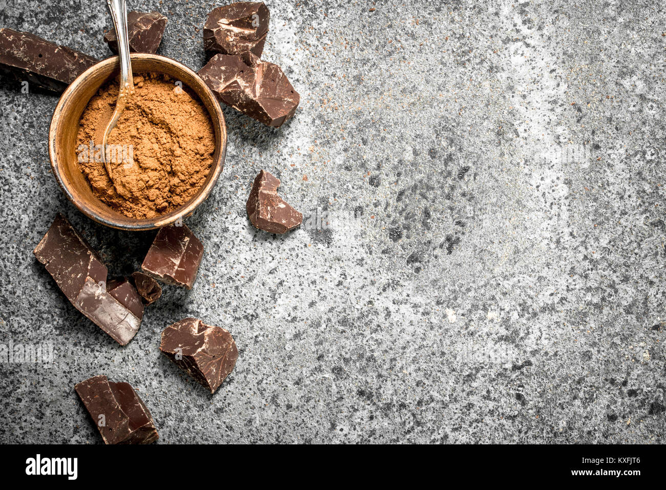 Chunks of chocolate with cocoa powder. On a rustic background Stock ...