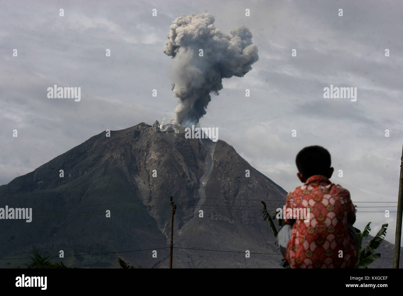 North Sumatra, Indonesia. 10th Jan, 2018. A boy watches volcanic ash ...