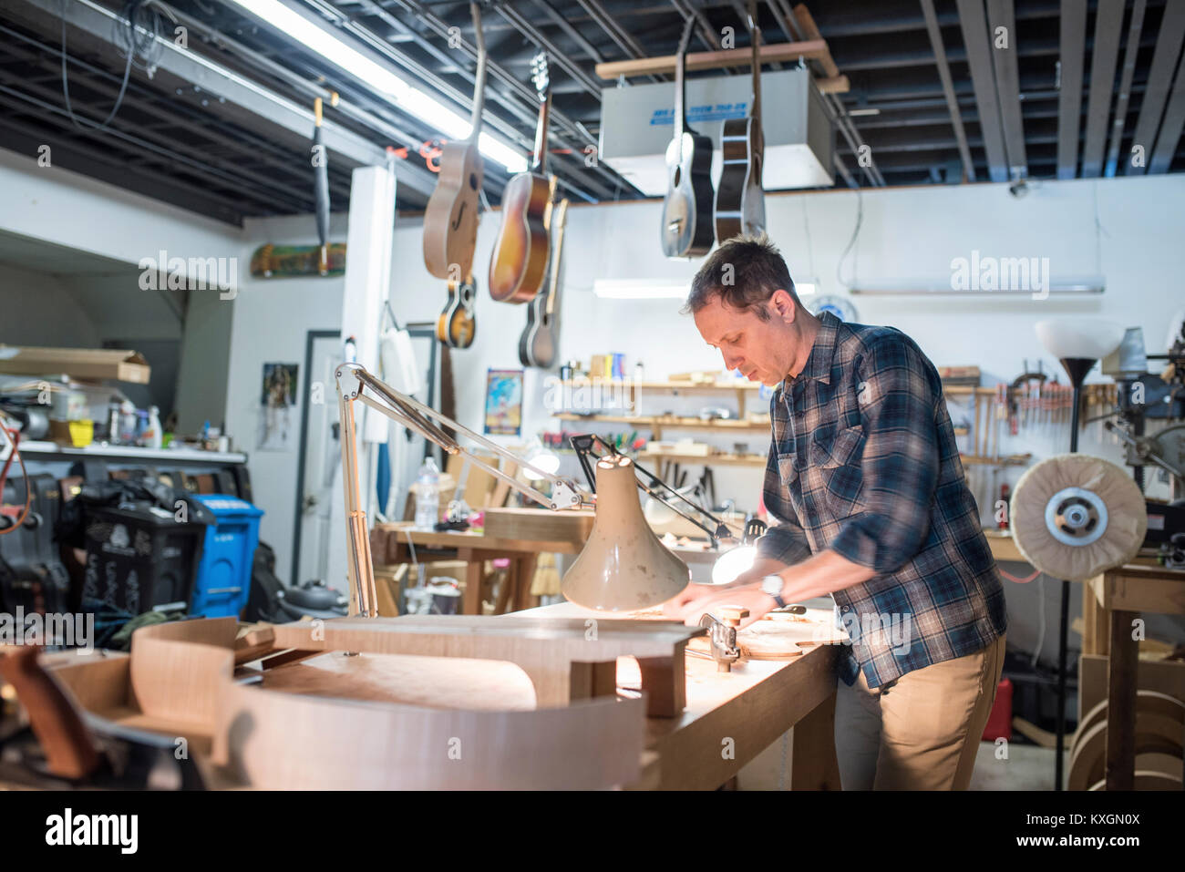 worker making guitar while standing at workbench in workshop Stock ...