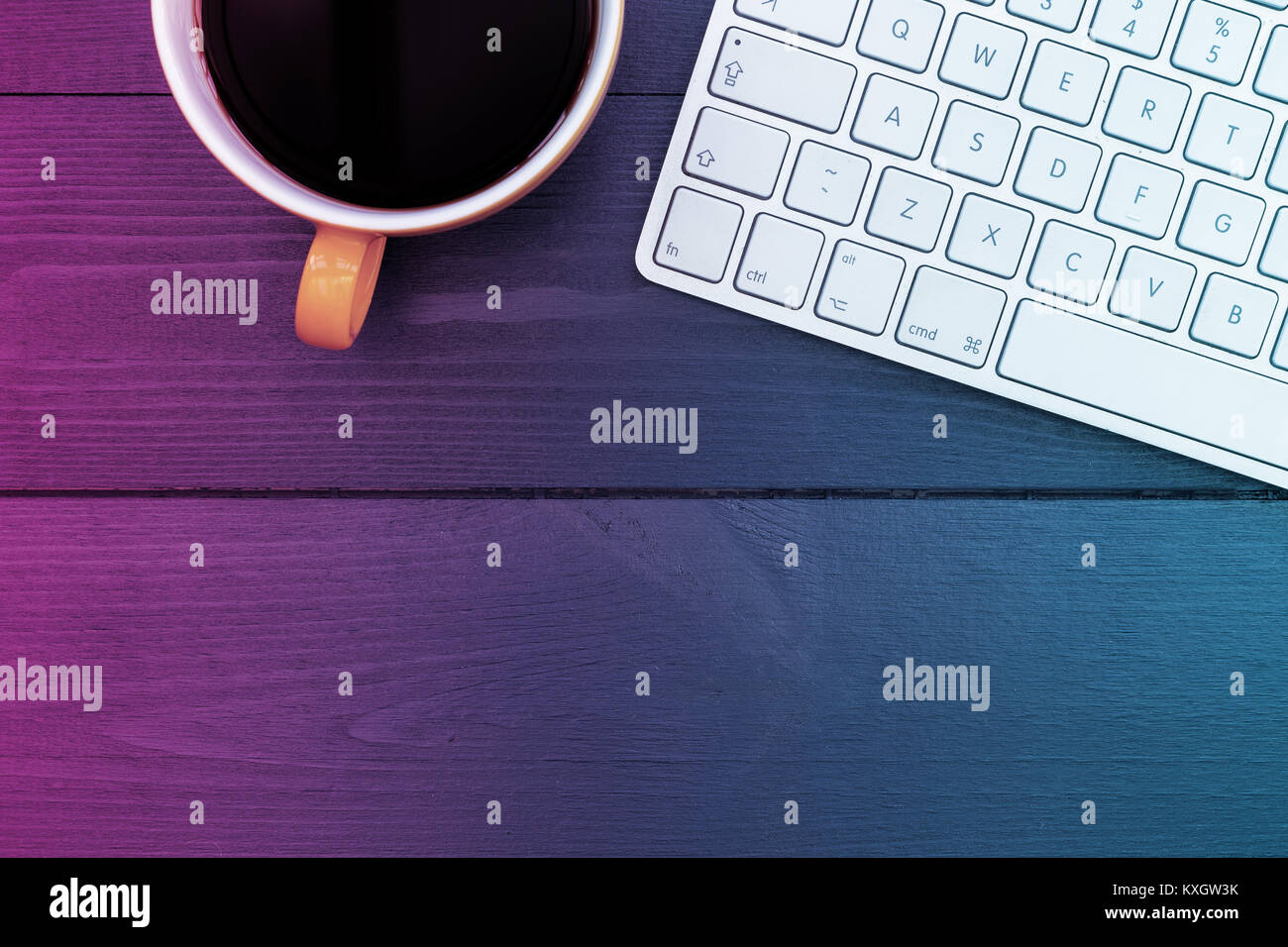 Coffee cup and computer keyboard on desk at night in office Stock Photo ...